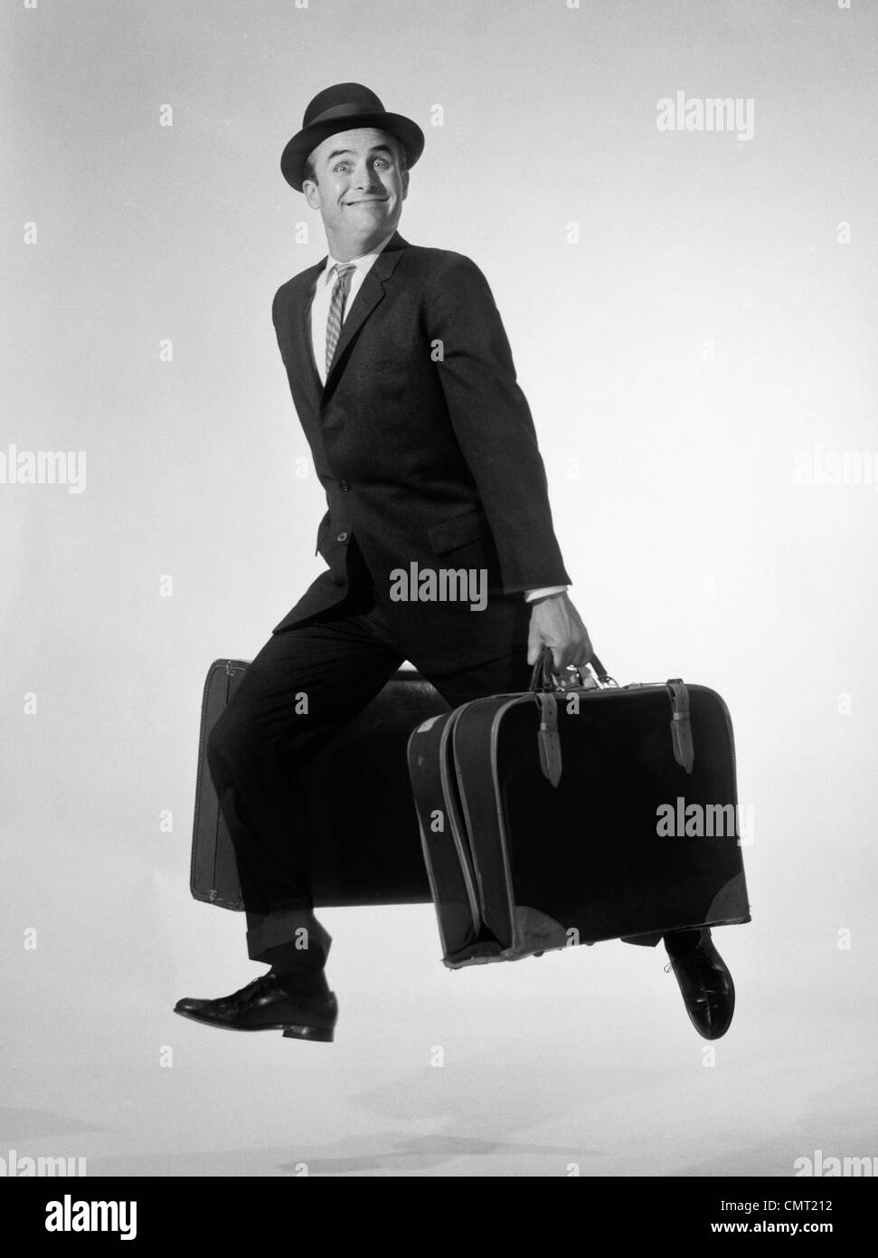 1950s SMILING MAN CARRYING TWO SUITCASES STEPPING OUT SALESMAN ...