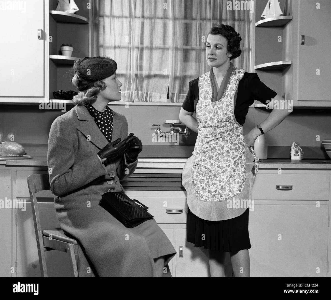 1930s 1940s TWO WOMEN SITTING IN KITCHEN TALKING ONE HOUSEWIFE ...