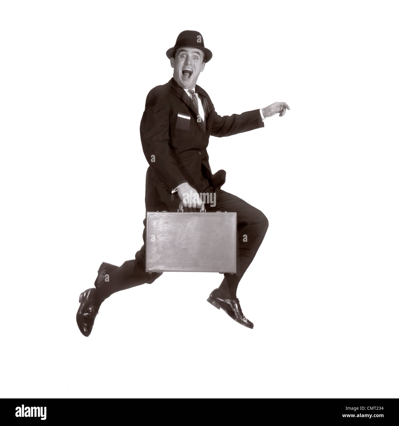 1960s SALESMAN LEAPING IN AIR HOLDING BRIEFCASE AND WEARING HAT LOOKING ...