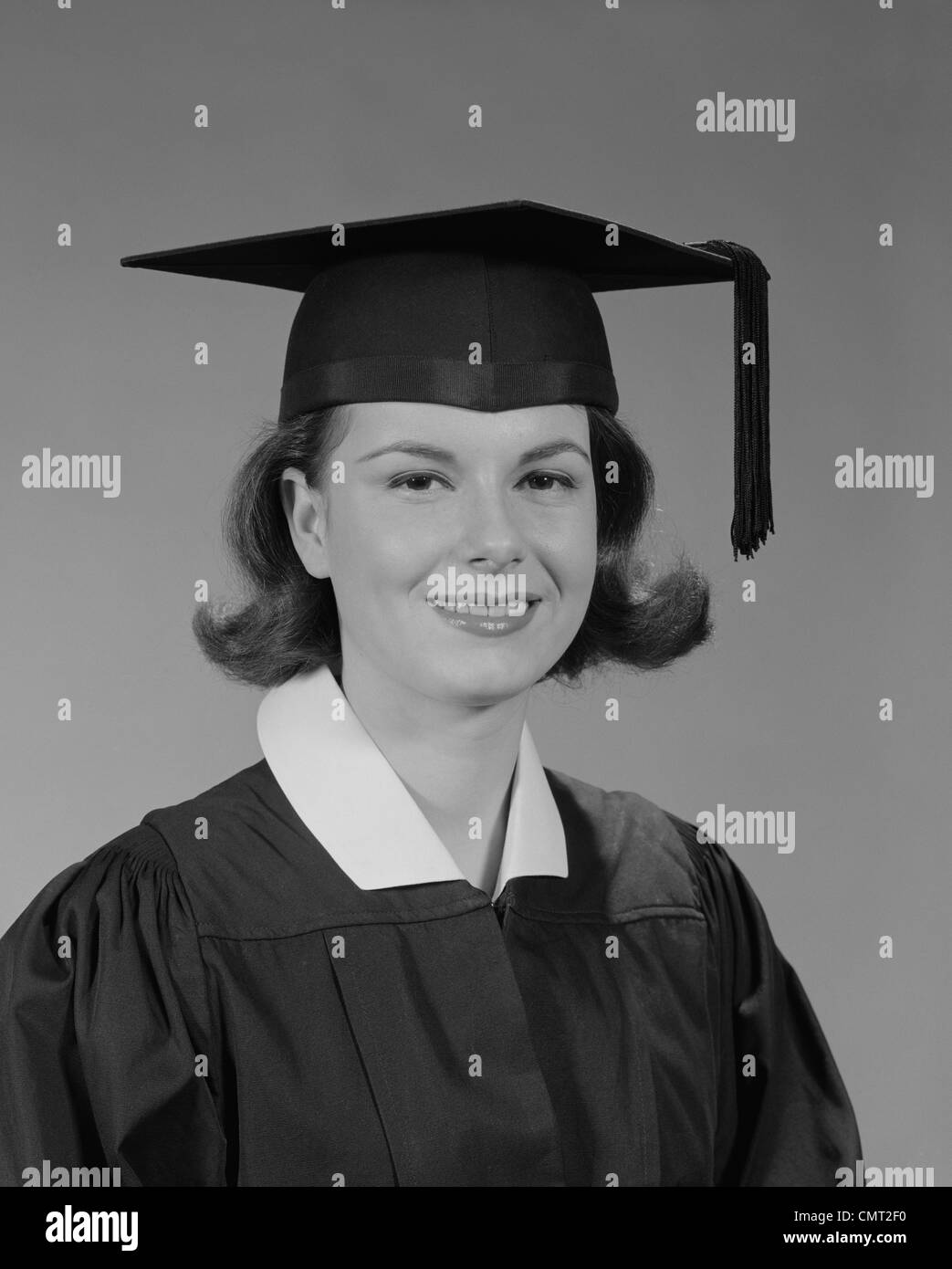 1960s PORTRAIT SMILING YOUNG WOMAN WEARING GRADUATION CAP AND GOWN ...