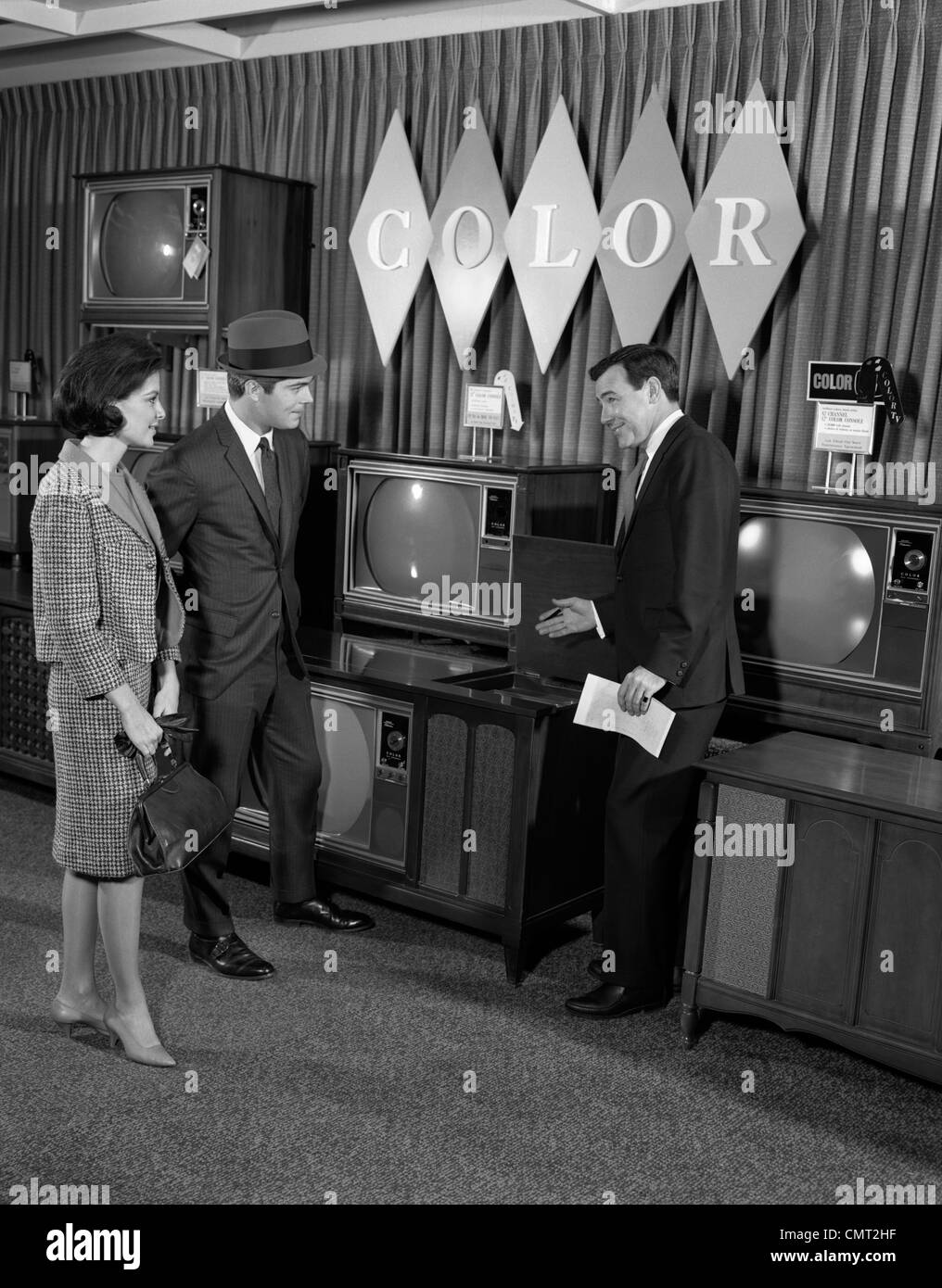 1960s COUPLE IN DEPARTMENT STORE WITH COLOR TV SALESMAN Stock Photo - Alamy