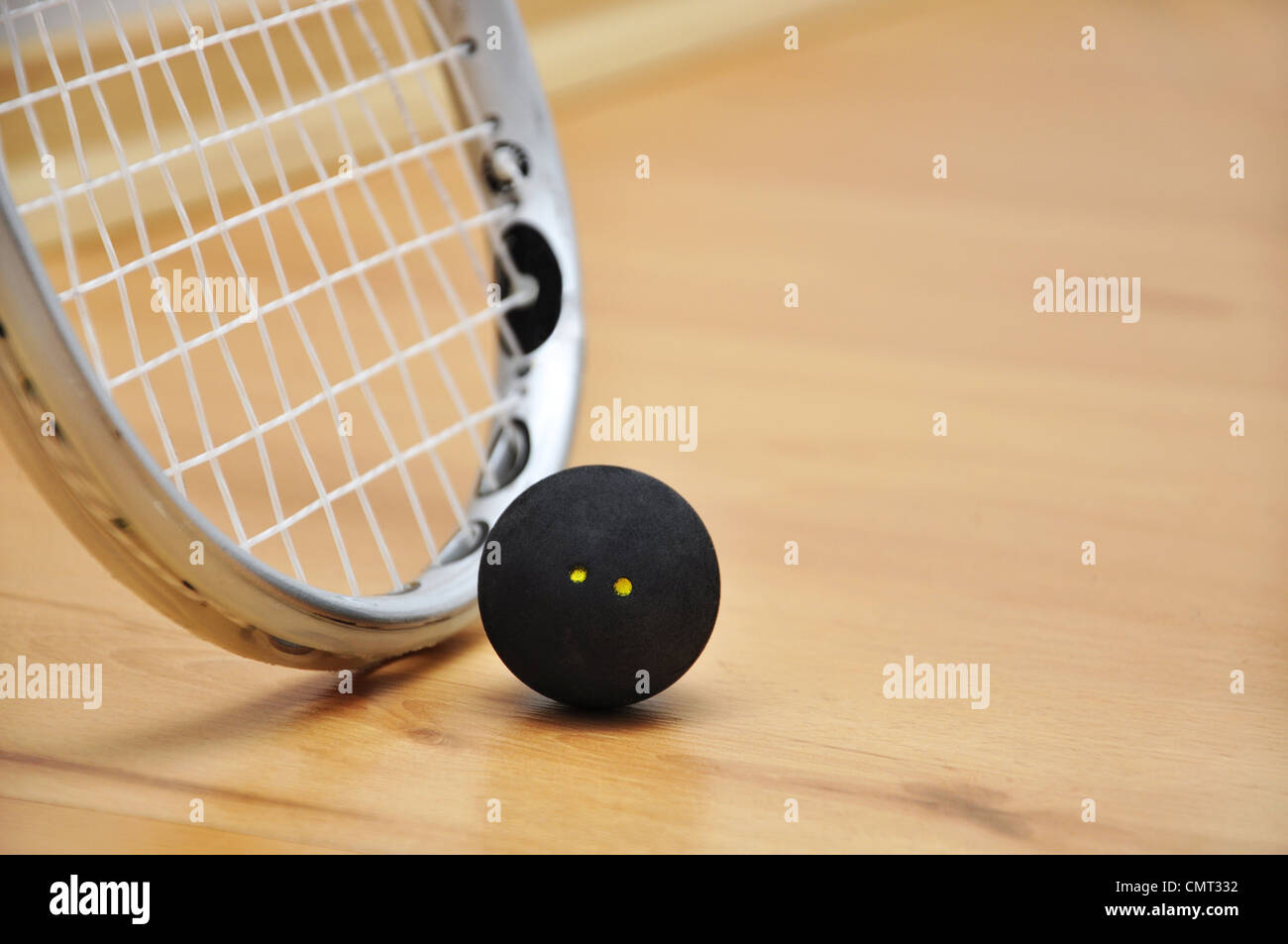 Close up of a squash racket and ball over wooden background Stock Photo ...