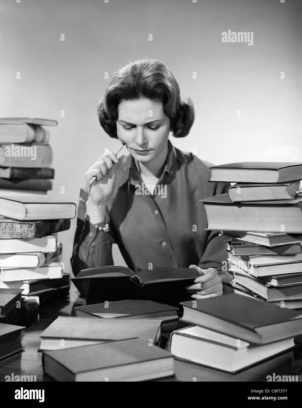 1950s 1960s COLLEGE WOMAN STUDYING SURROUNDED ALL AROUND BY PILES OF ...