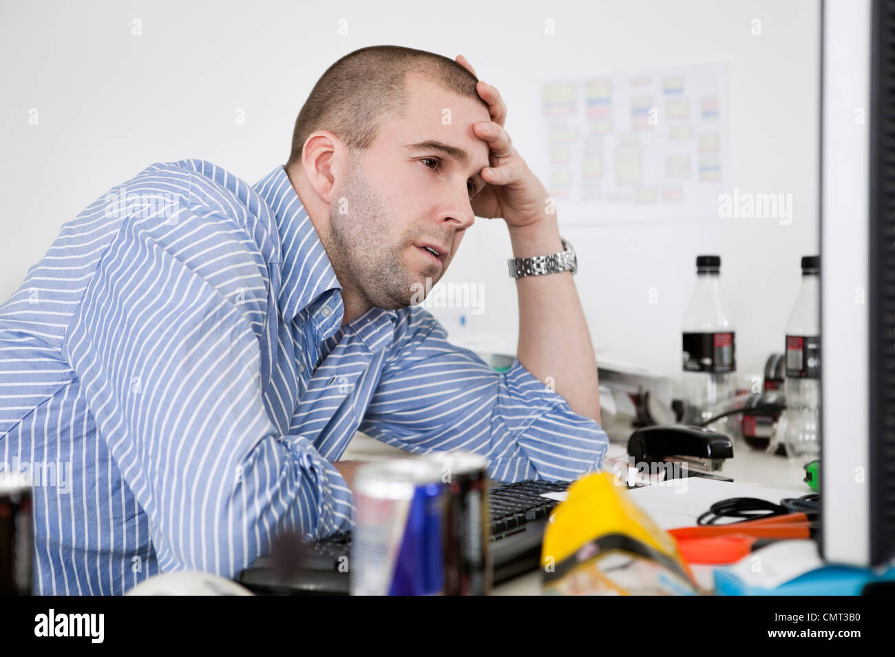 Tired man sitting by computer Stock Photo - Alamy