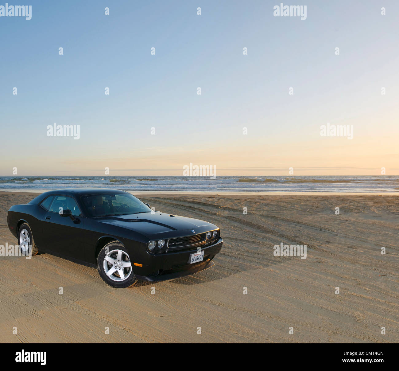 retro car on sandy beach in USA California at sunset with sea and ...