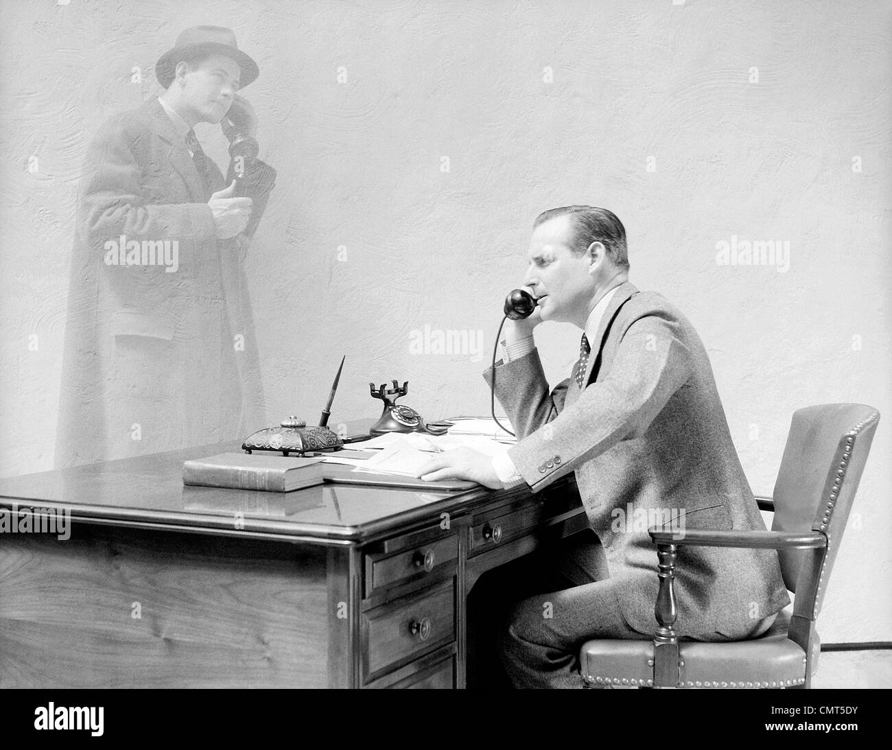1930s 1940s BUSINESSMAN AT DESK TALKING ON TELEPHONE TO SALESMAN CLIENT ...
