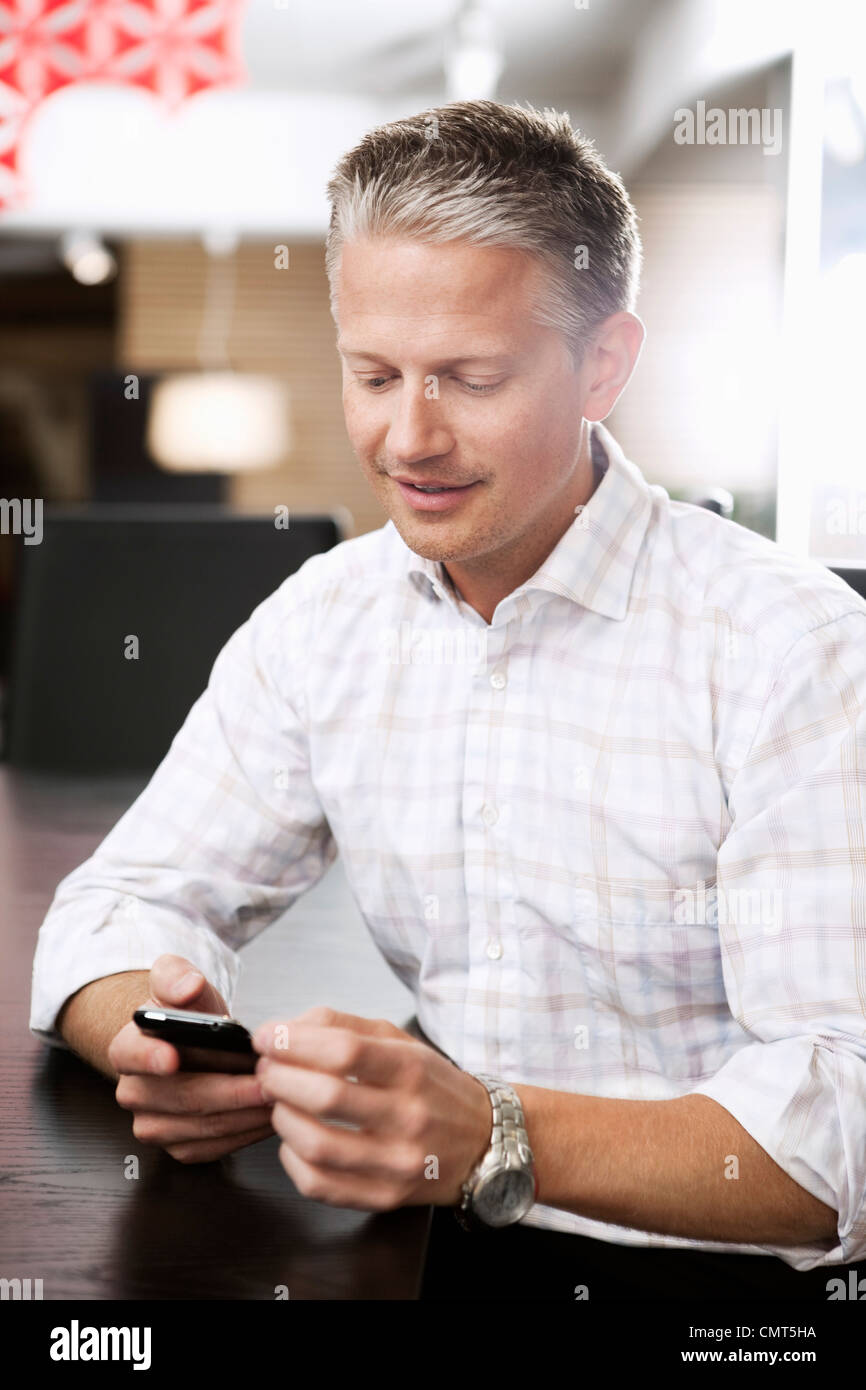 Handsome businessman texting message through cell phone Stock Photo - Alamy