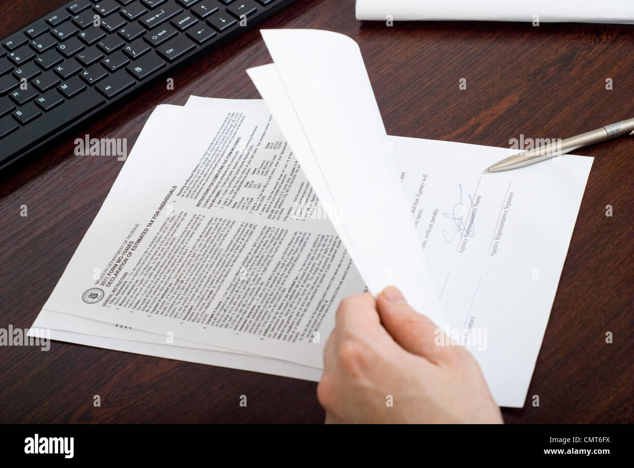 Business man reading all pages of the 1040 tax form Stock Photo - Alamy