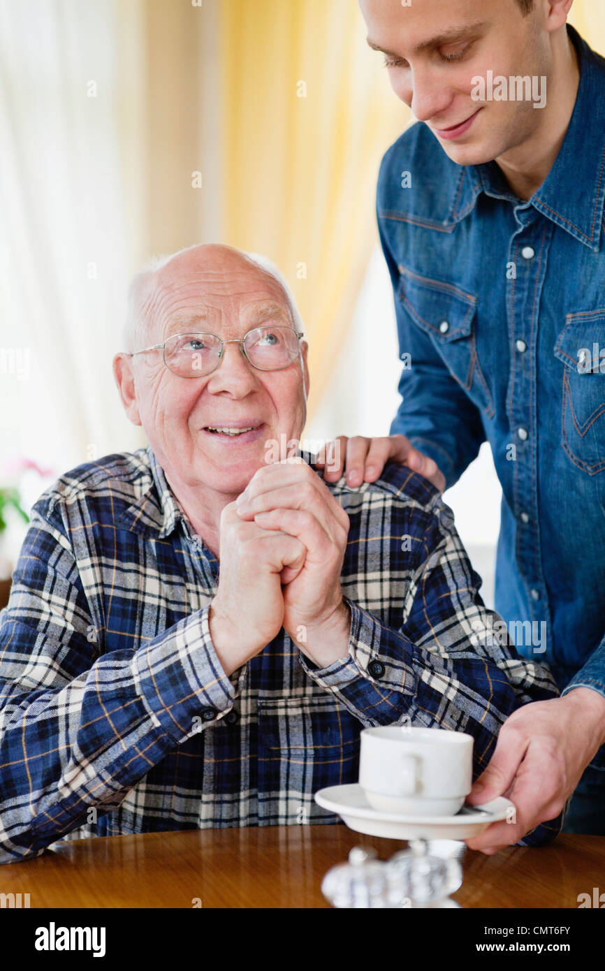 Young man serving coffee to his grandfather Stock Photo - Alamy