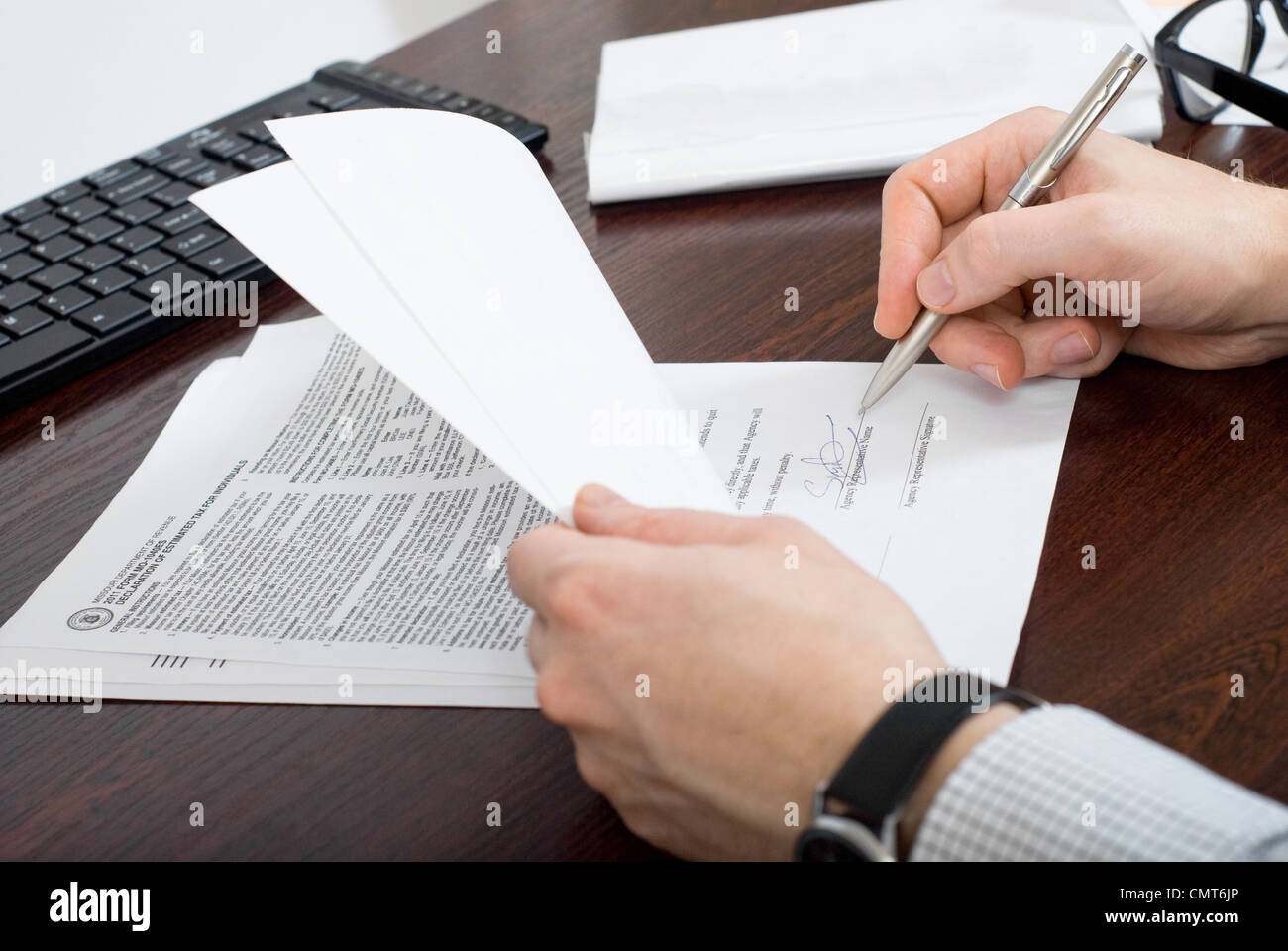 Business man signing all pages of the 1040 tax form after reading and ...