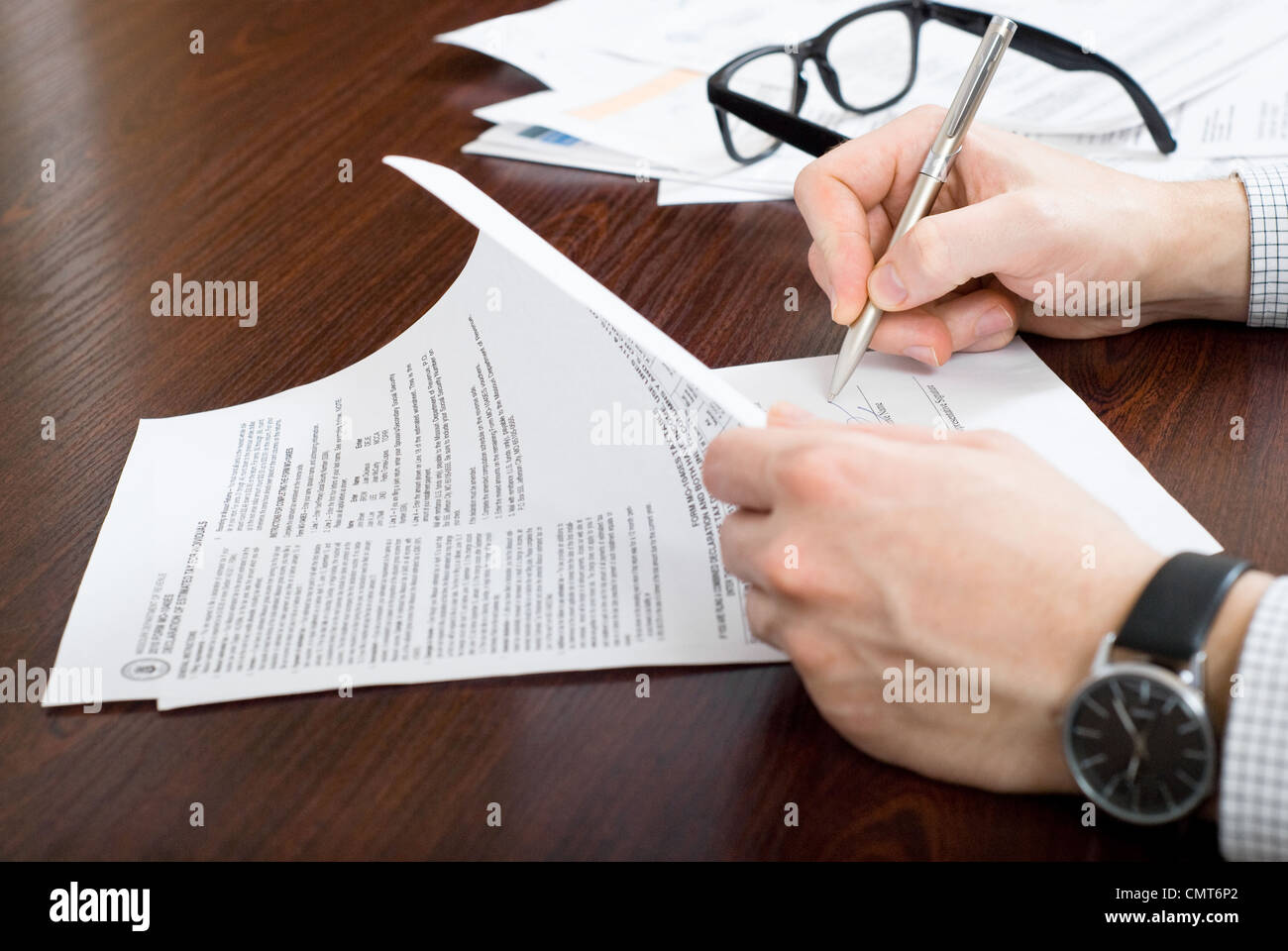 Business man signing the1040 tax form after reading it Stock Photo - Alamy