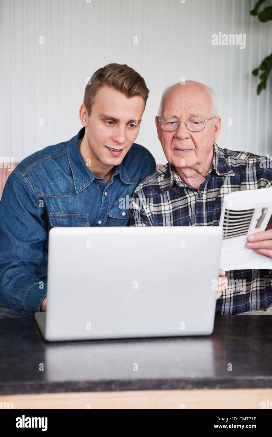 Young man teaching his grandfather about computers Stock Photo - Alamy