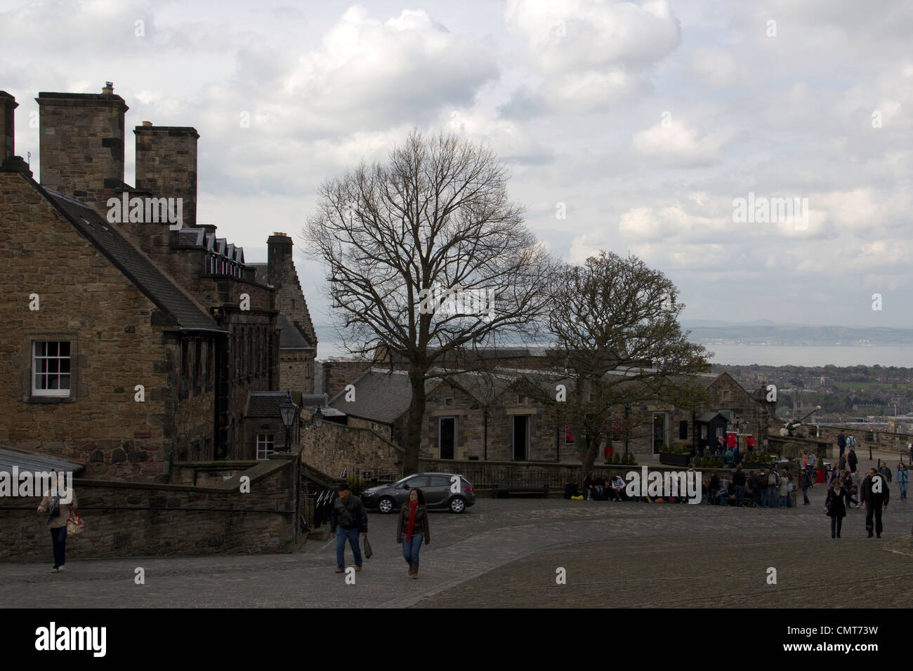 Walking uphill inside the Edinburgh Castle. The view shows trees ...