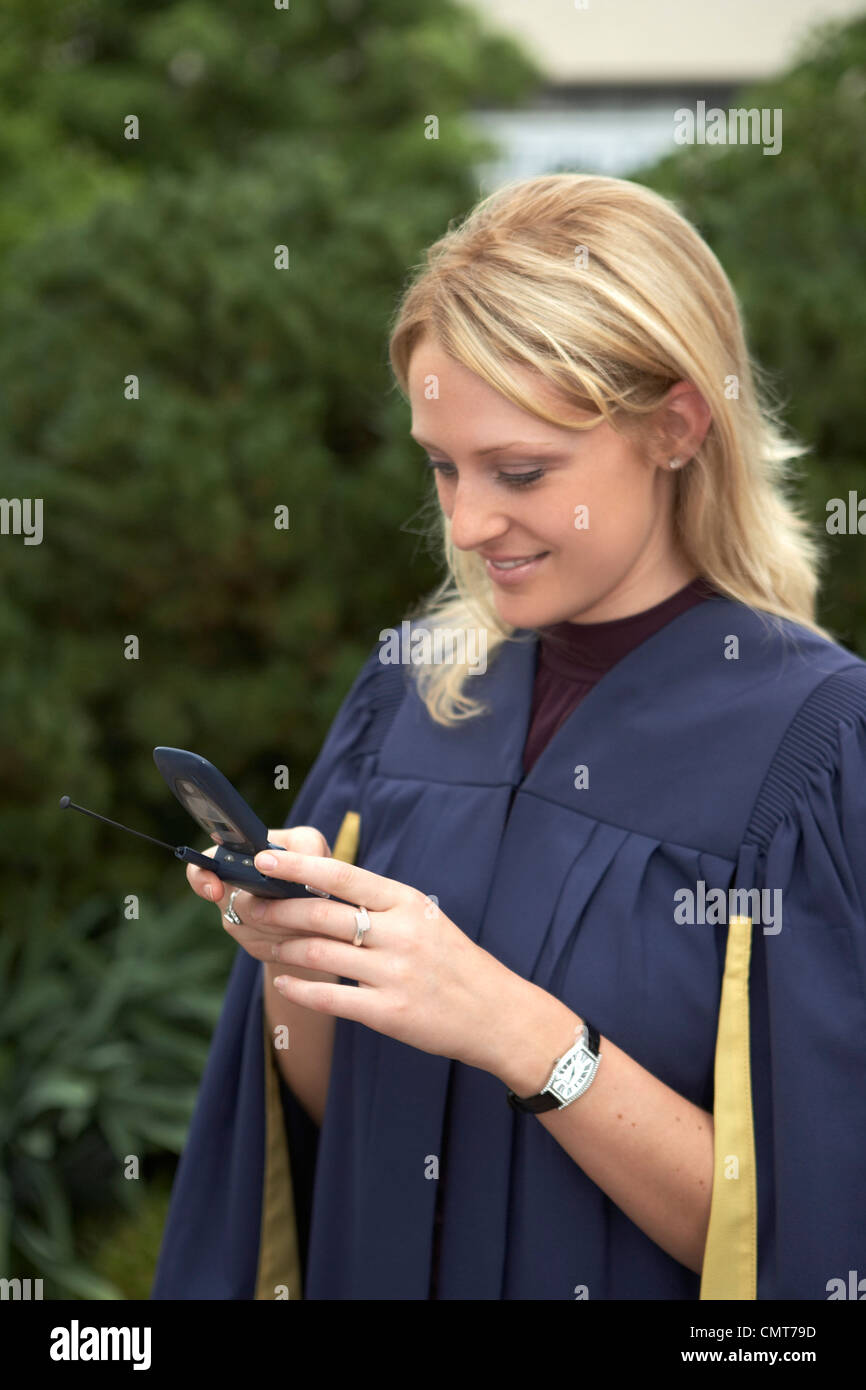 Woman in Graduation Gown holding Cell Phone, Toronto, Ontario Stock ...