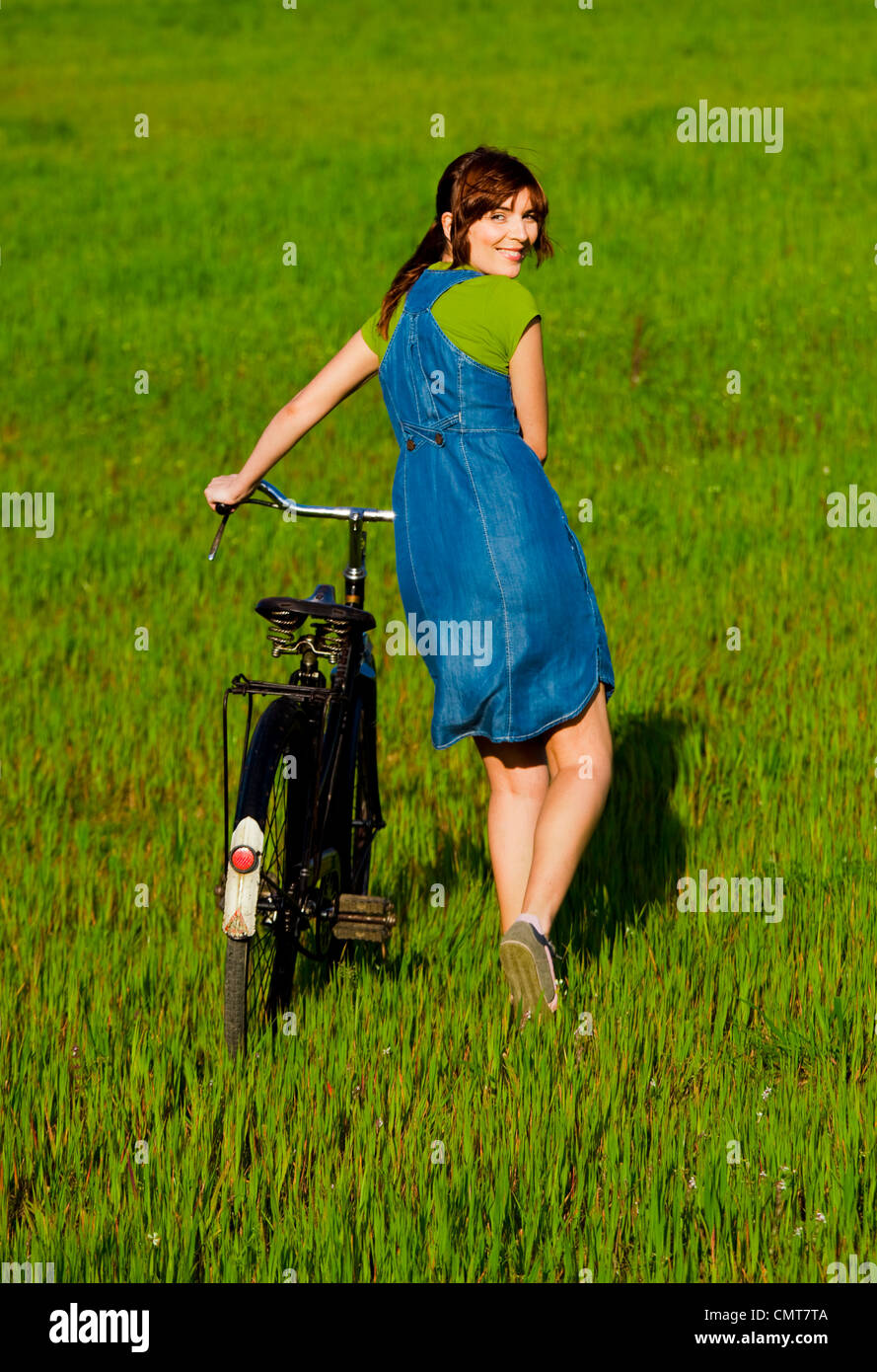 Young woman walking side by side with a bicycle Stock Photo - Alamy