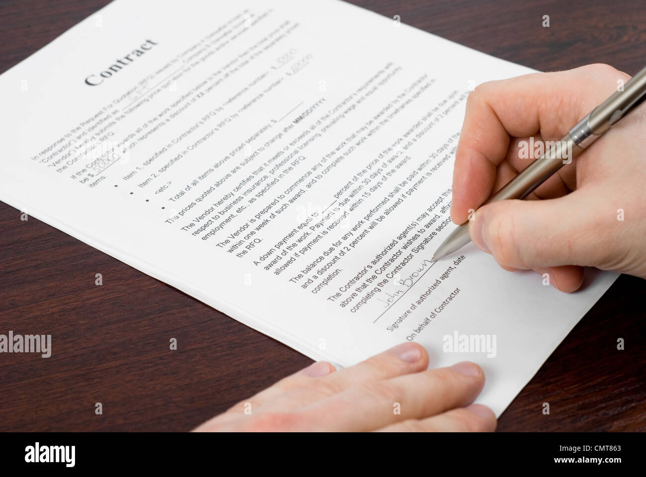 Signing contract on brown table Stock Photo - Alamy