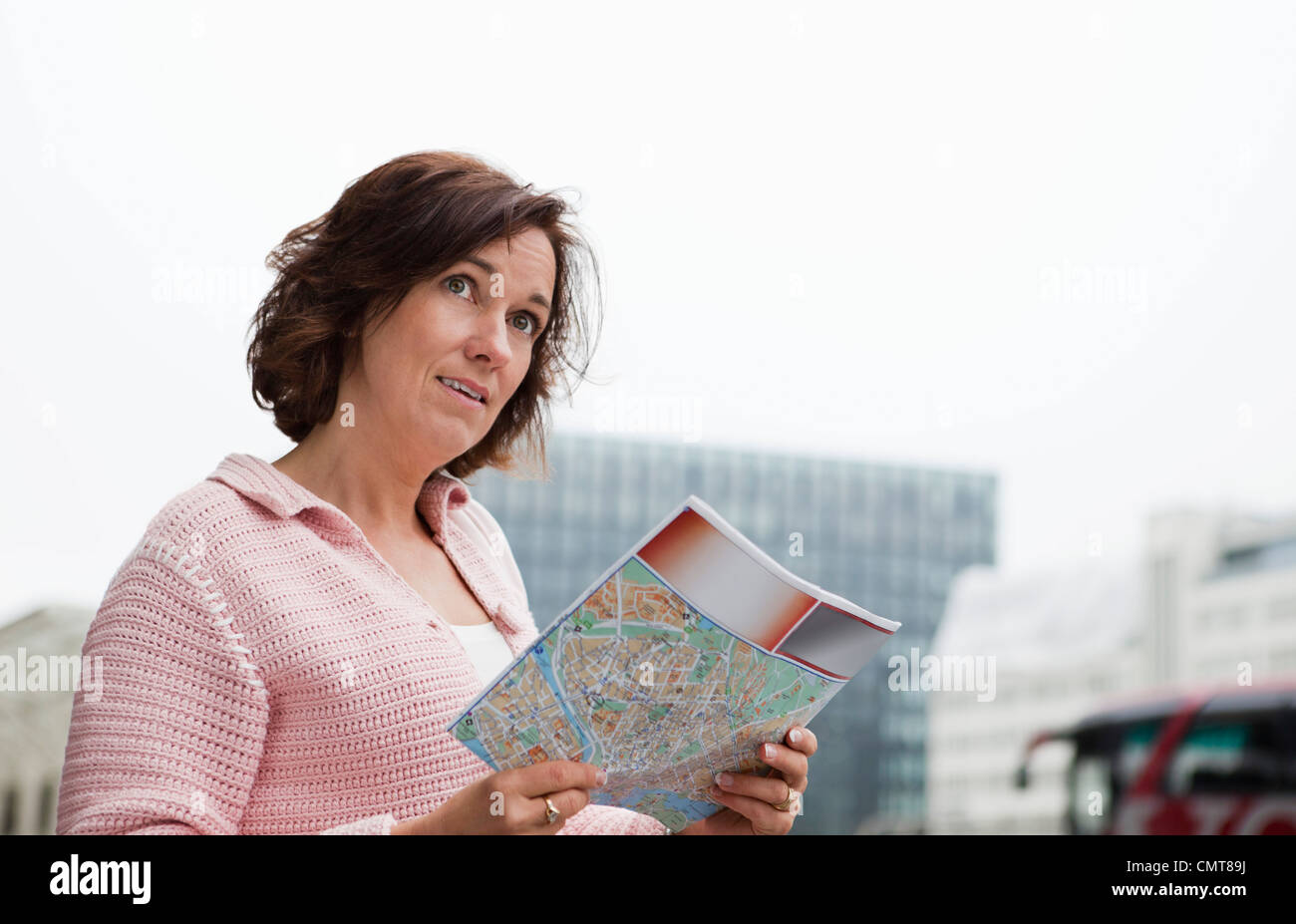 Confused woman holding map hi-res stock photography and images - Alamy