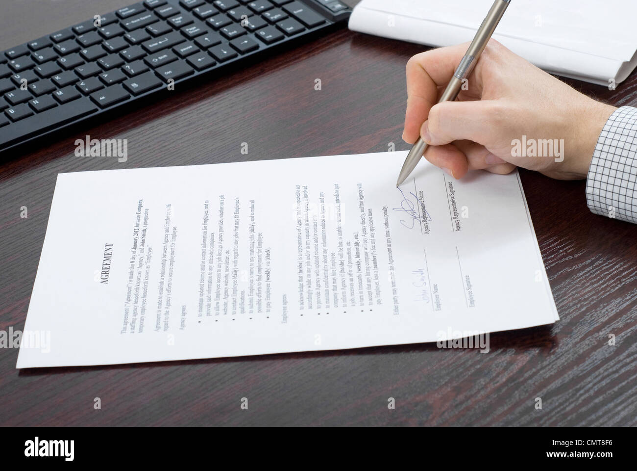Business person signing contract at his desk Stock Photo - Alamy