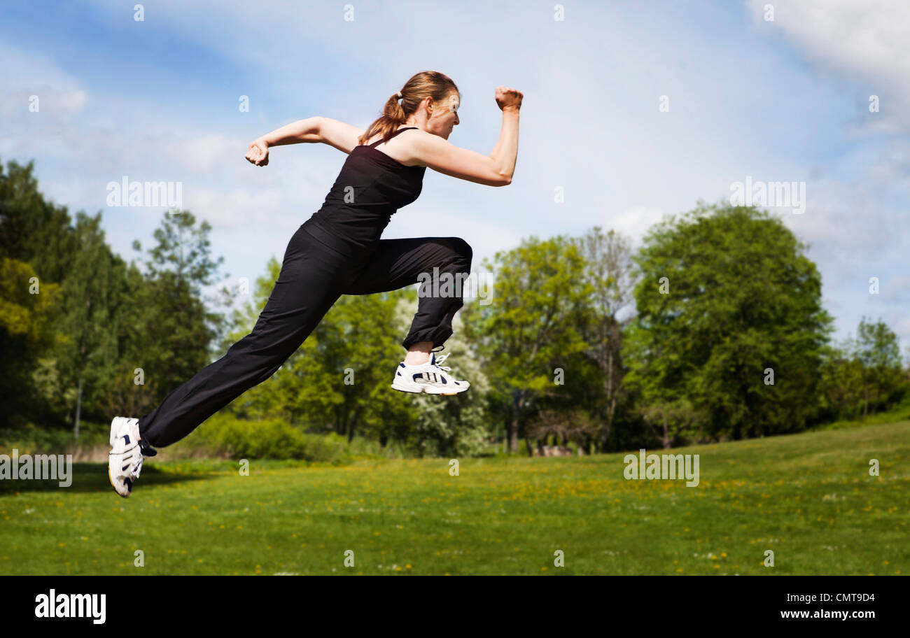Woman in middle of jump Stock Photo - Alamy