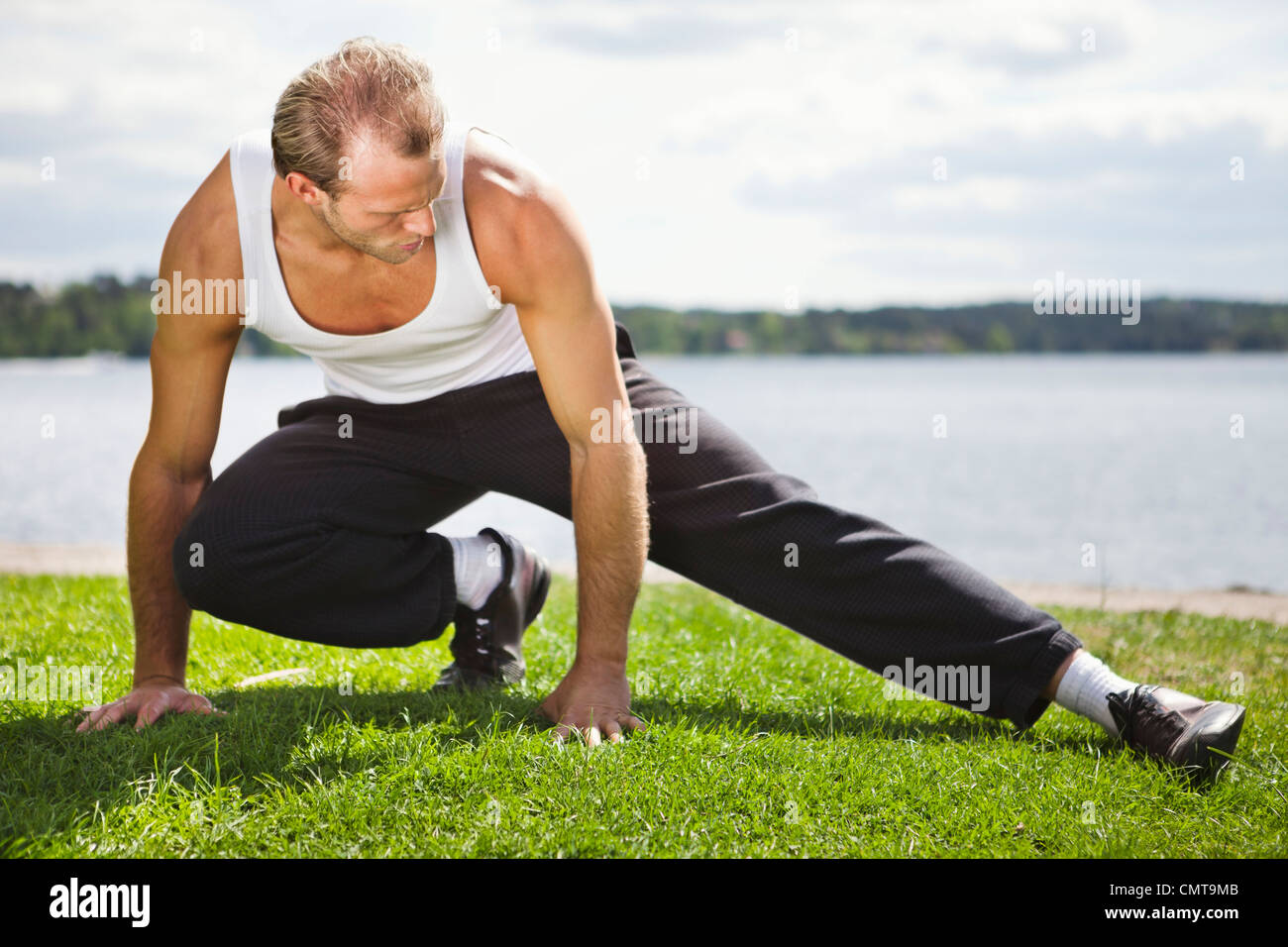 Man stretching on grass at park Stock Photo - Alamy