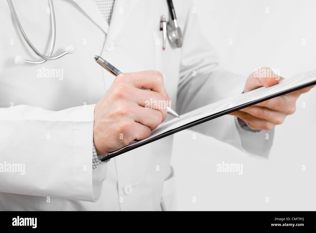 Doctor writing something on clipboard Stock Photo - Alamy
