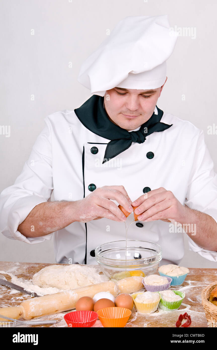 Chef breaks an egg into a bowl Stock Photo - Alamy