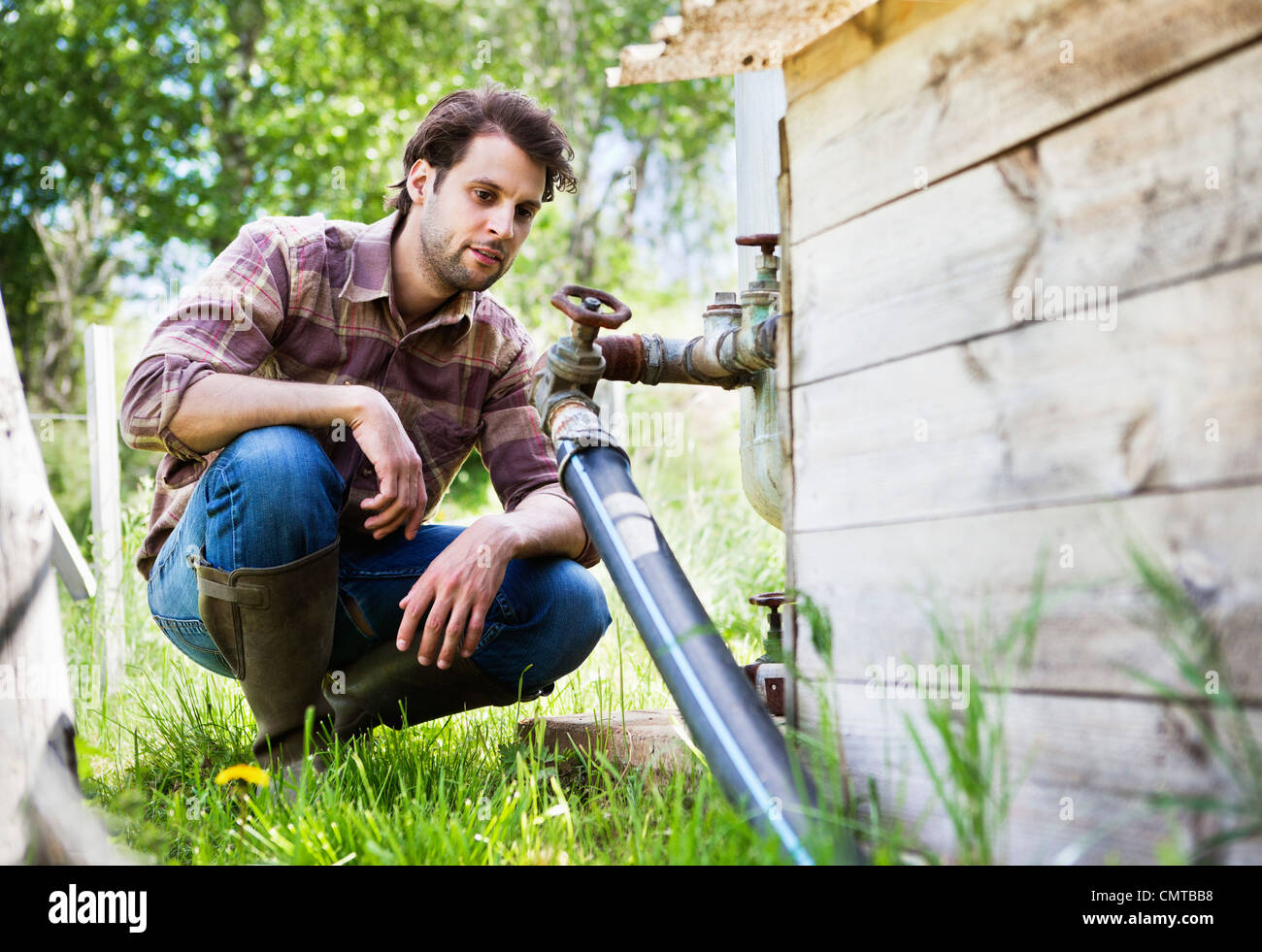 Man looking at water pipe Stock Photo - Alamy