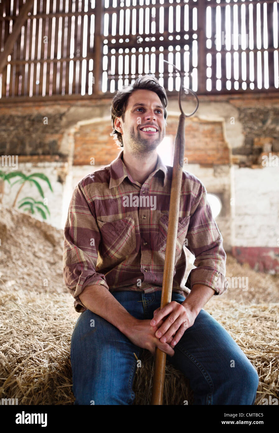 Happy farmer with hayfork Stock Photo - Alamy