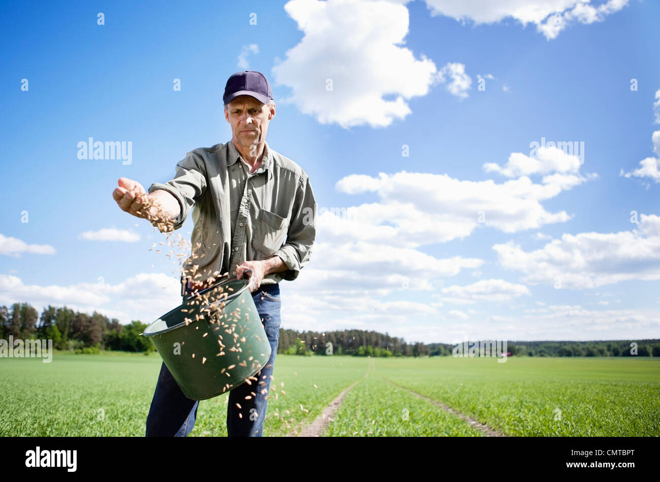 Farmer sowing seeds in field Stock Photo - Alamy