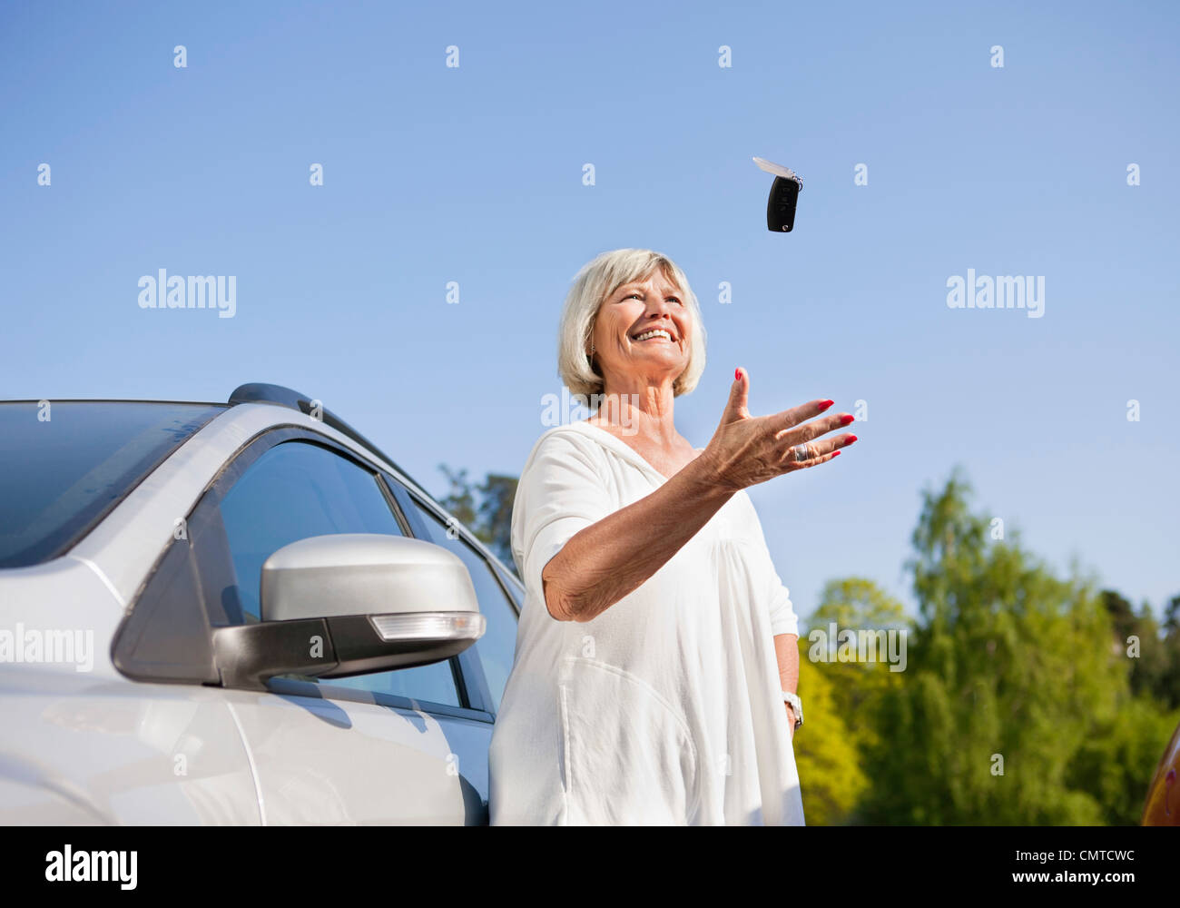 Senior woman throwing car keys Stock Photo - Alamy