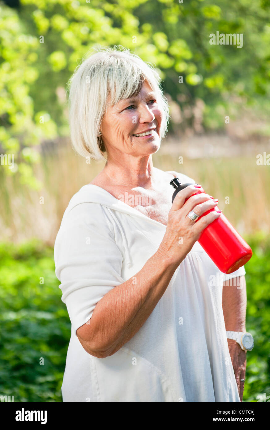 Senior woman holding water bottle Stock Photo - Alamy