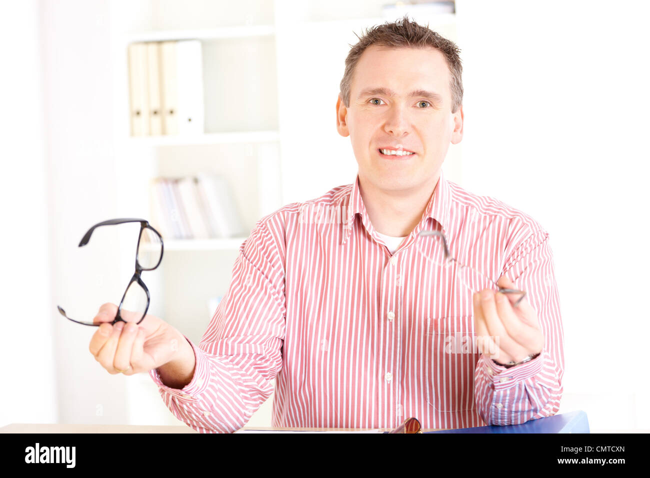 Male optician oculist presenting new glasses Stock Photo - Alamy
