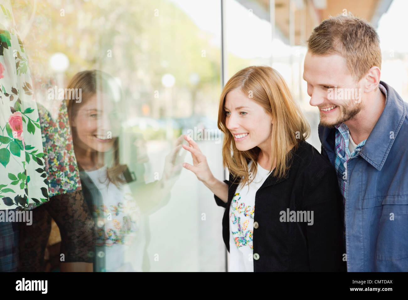 Couple looking through display window Stock Photo - Alamy