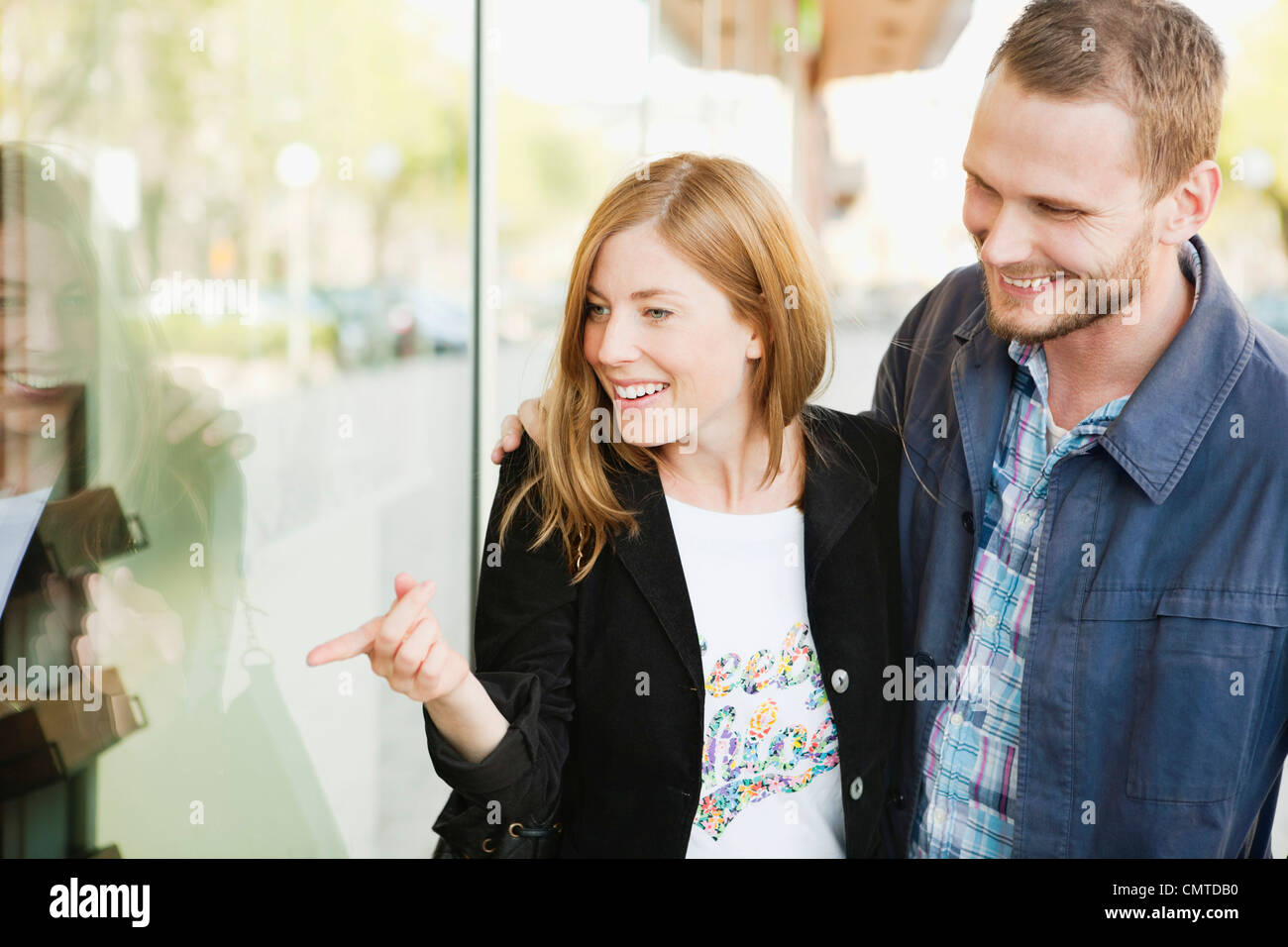 Couple pointing at window display Stock Photo - Alamy