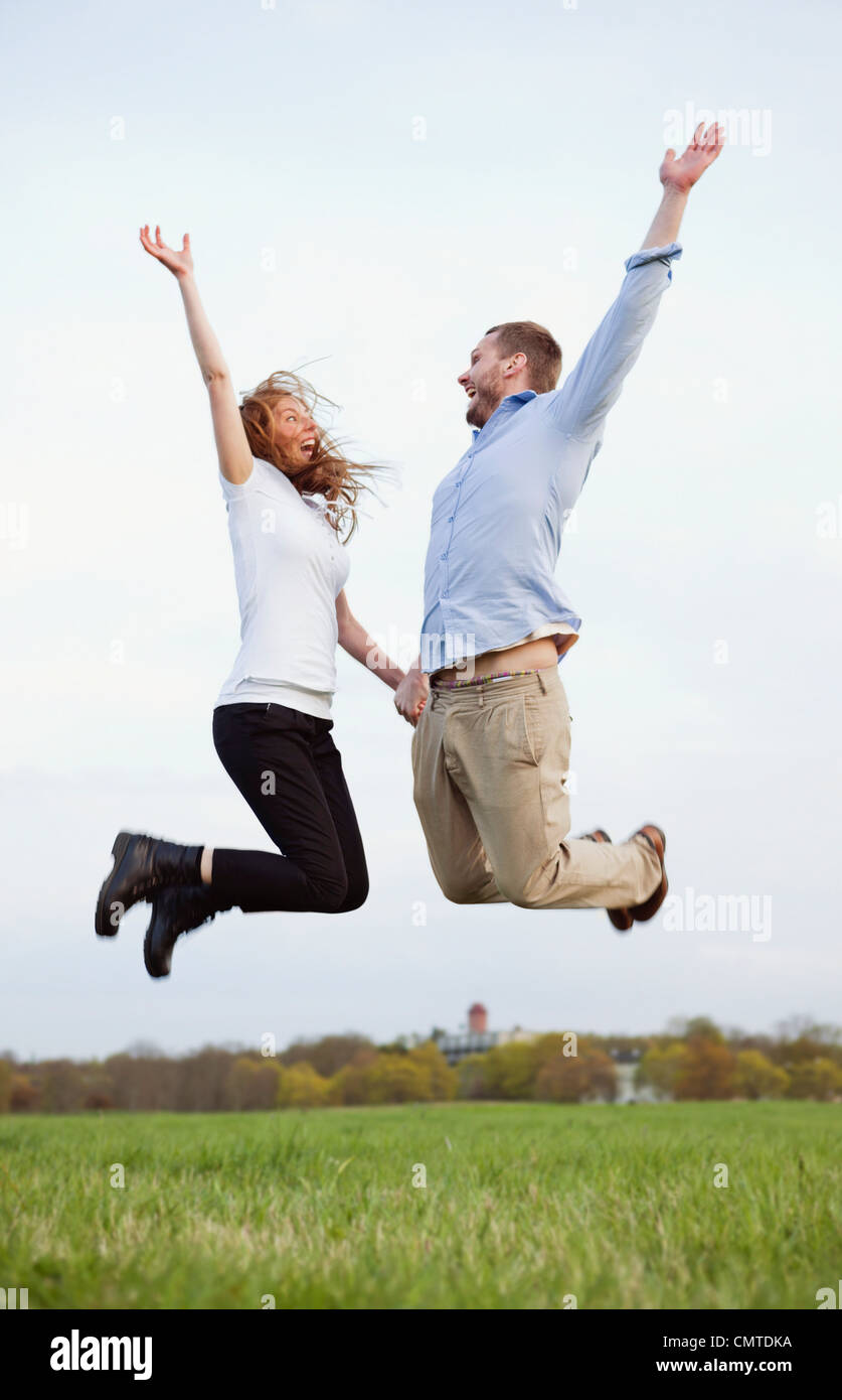 Carefree couple jumping park hi-res stock photography and images - Alamy