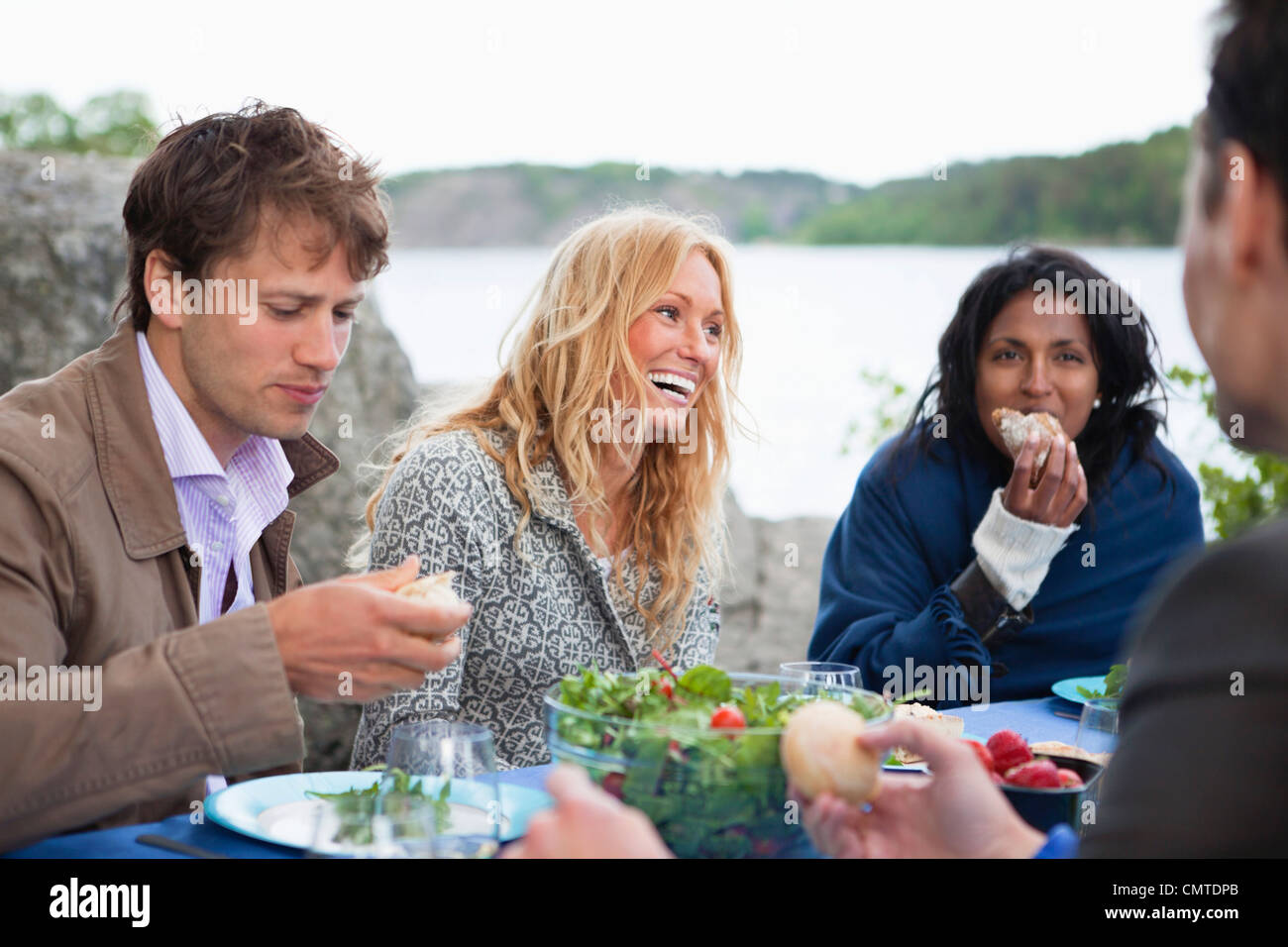 Friends dining together on beach Stock Photo - Alamy