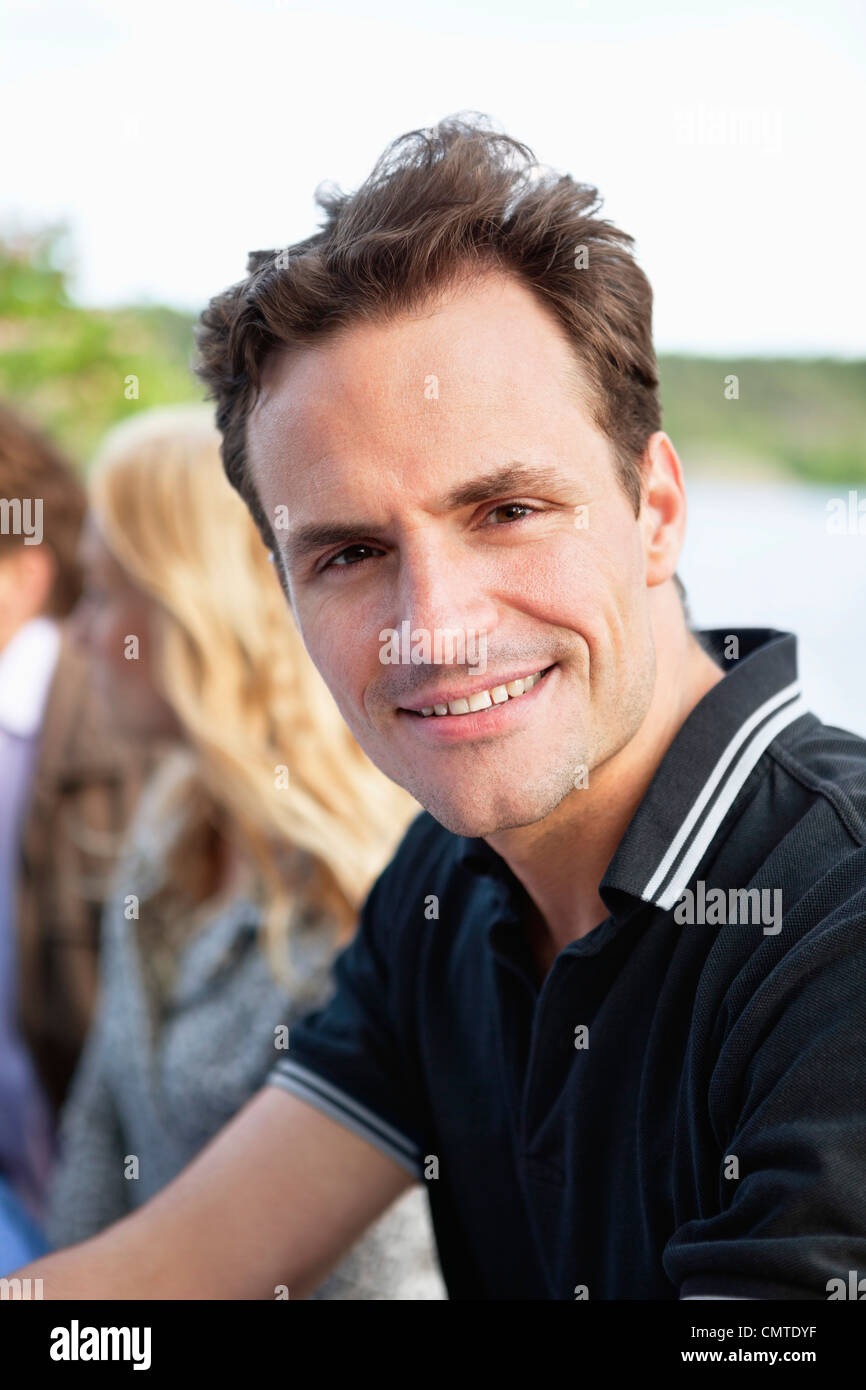 Portrait of man with friends in background Stock Photo - Alamy
