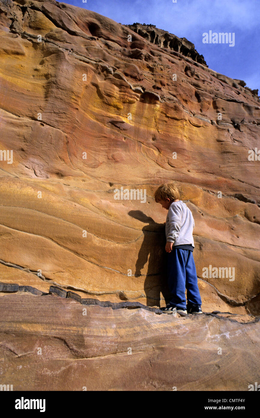 Western child looking at a colorful sandstone rock surface in the Sinai ...