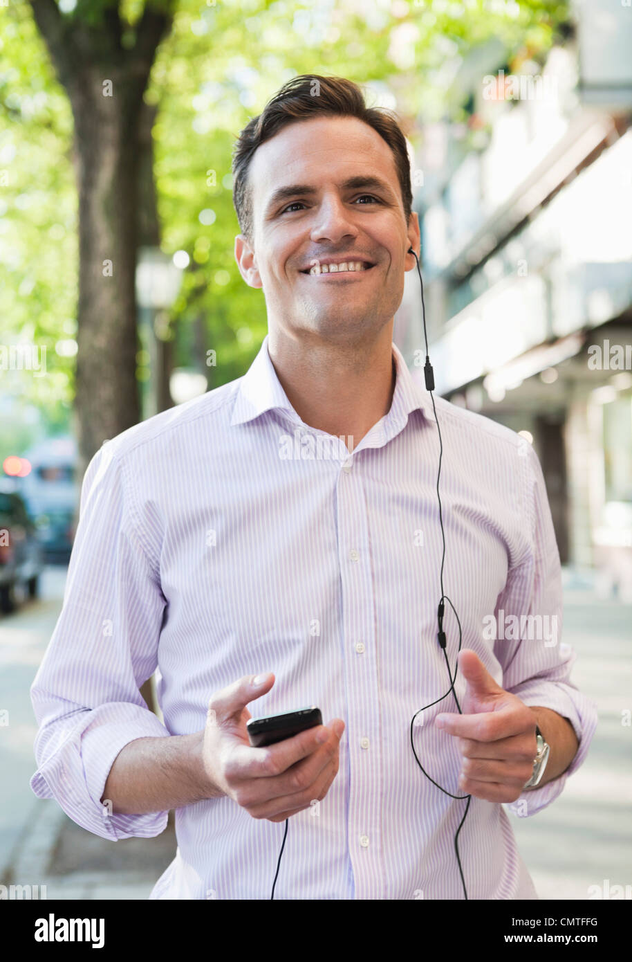 Smiling man with headset and mobile phone Stock Photo - Alamy