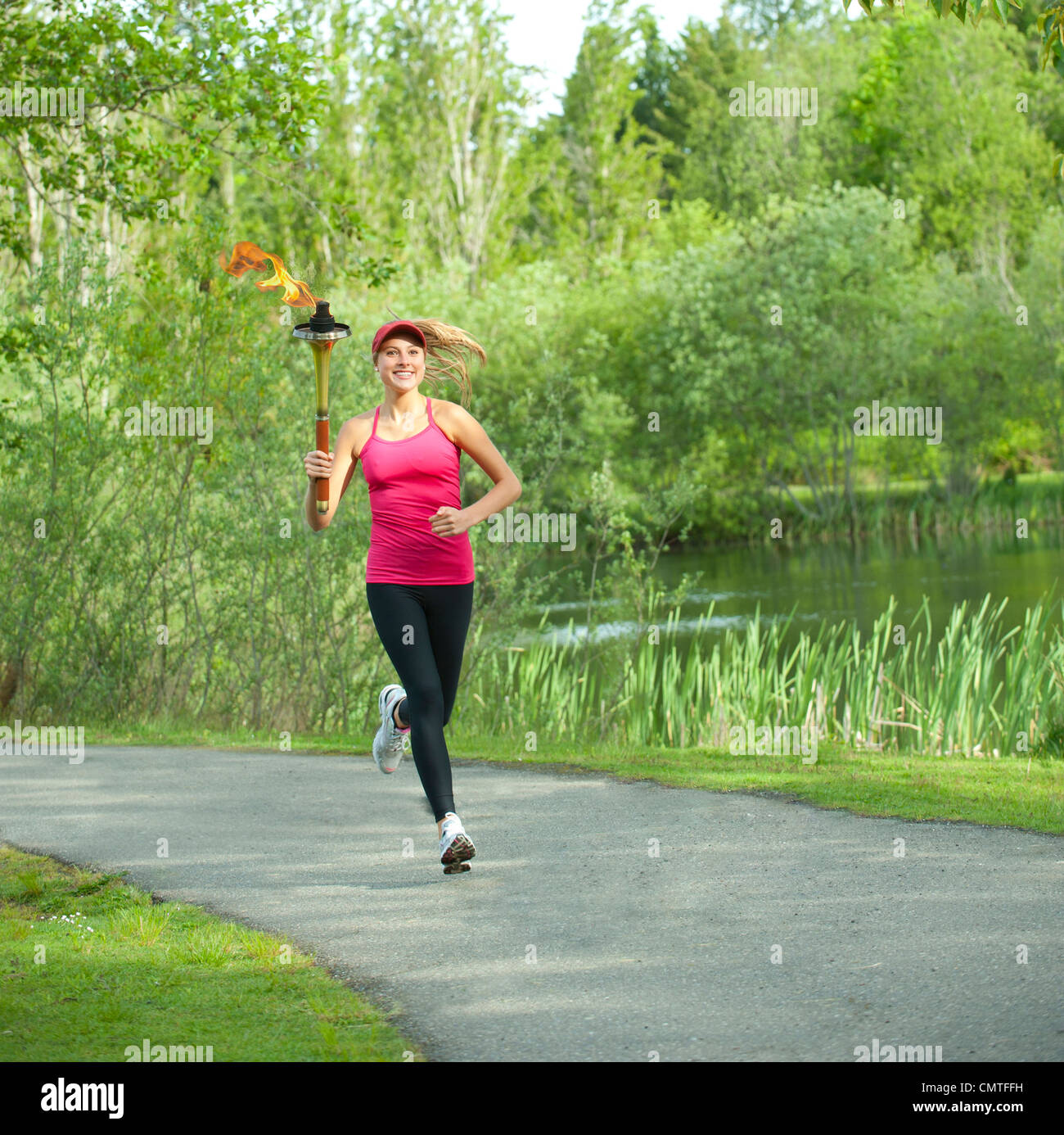 Caucasian athlete running with Olympic torch on park path Stock Photo ...