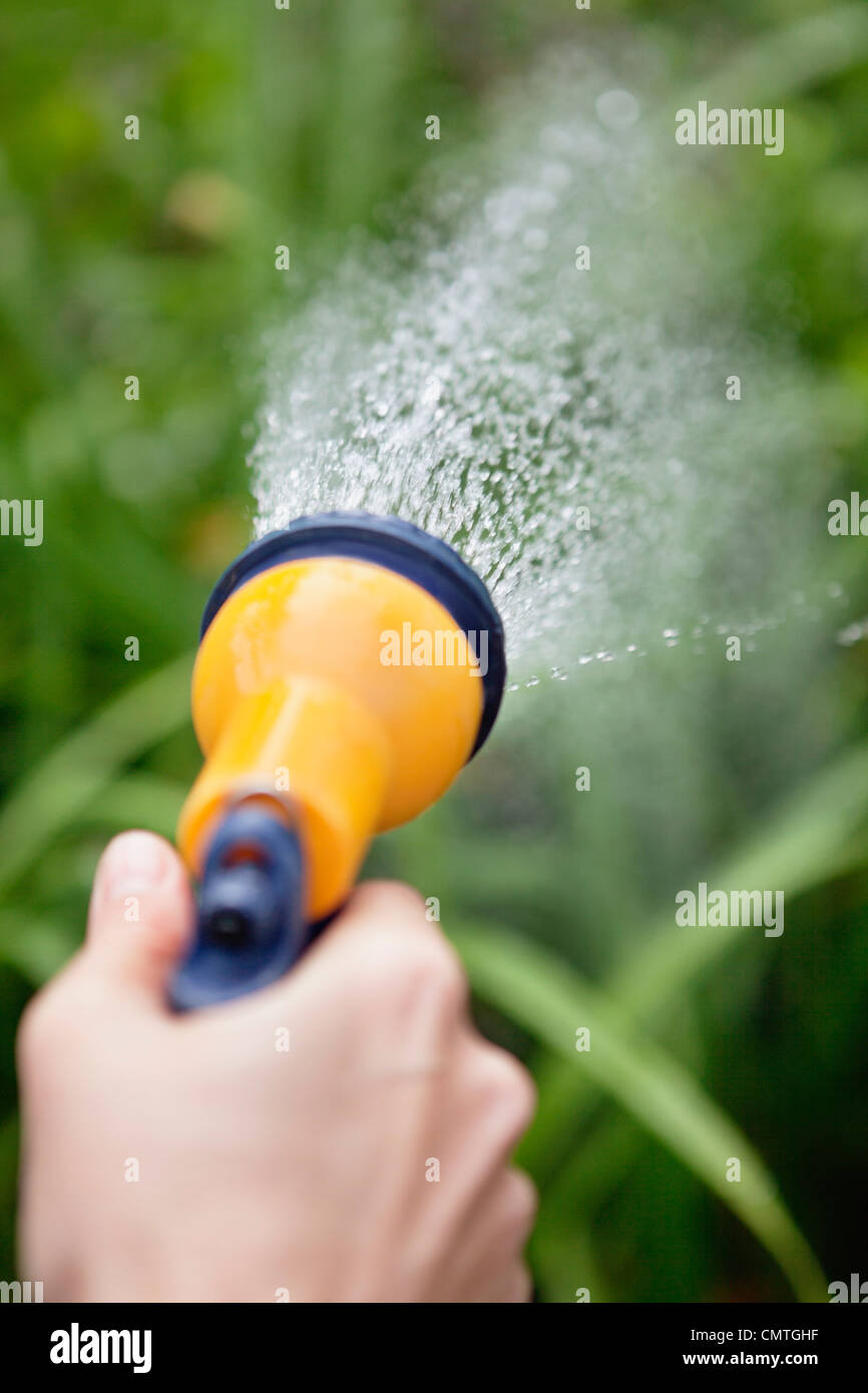 Man spraying water Stock Photo - Alamy
