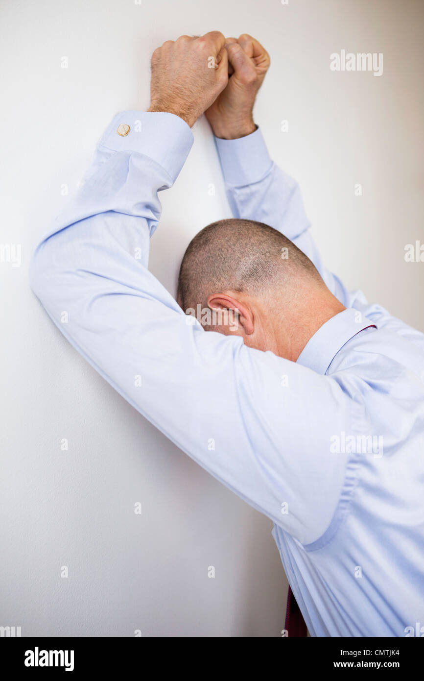 businessman leaning against wall Stock Photo - Alamy