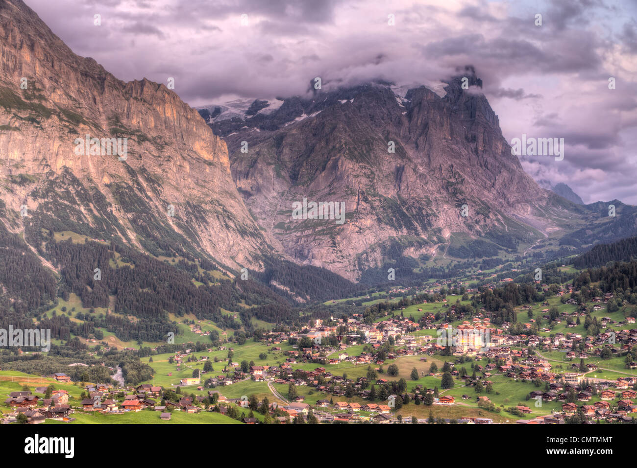 Famous alpine town Grindelwald in valley at sunset in front of mountain ...
