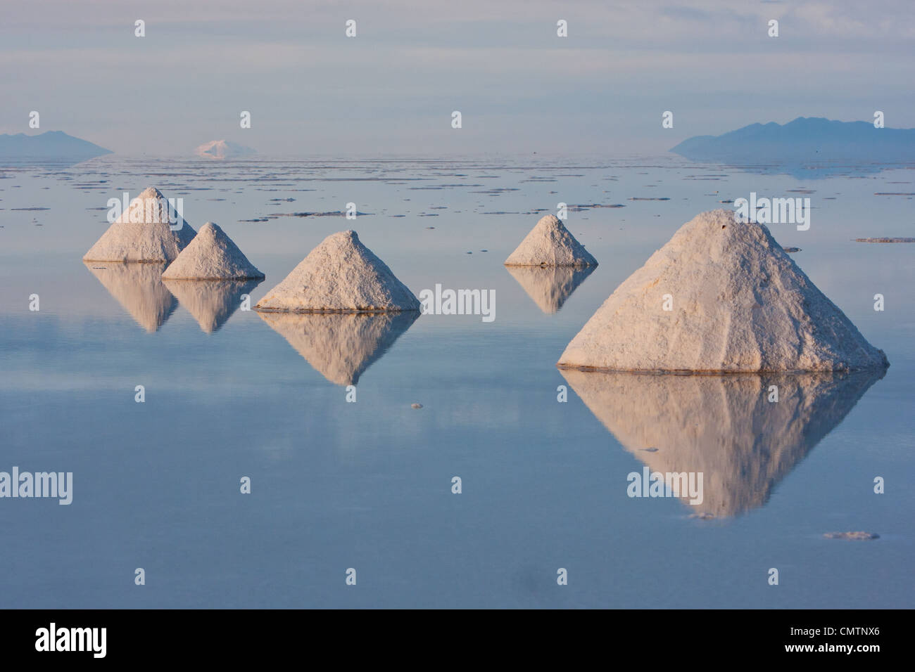 Piles of salt, drying for harvest are reflected in the mirror-like ...