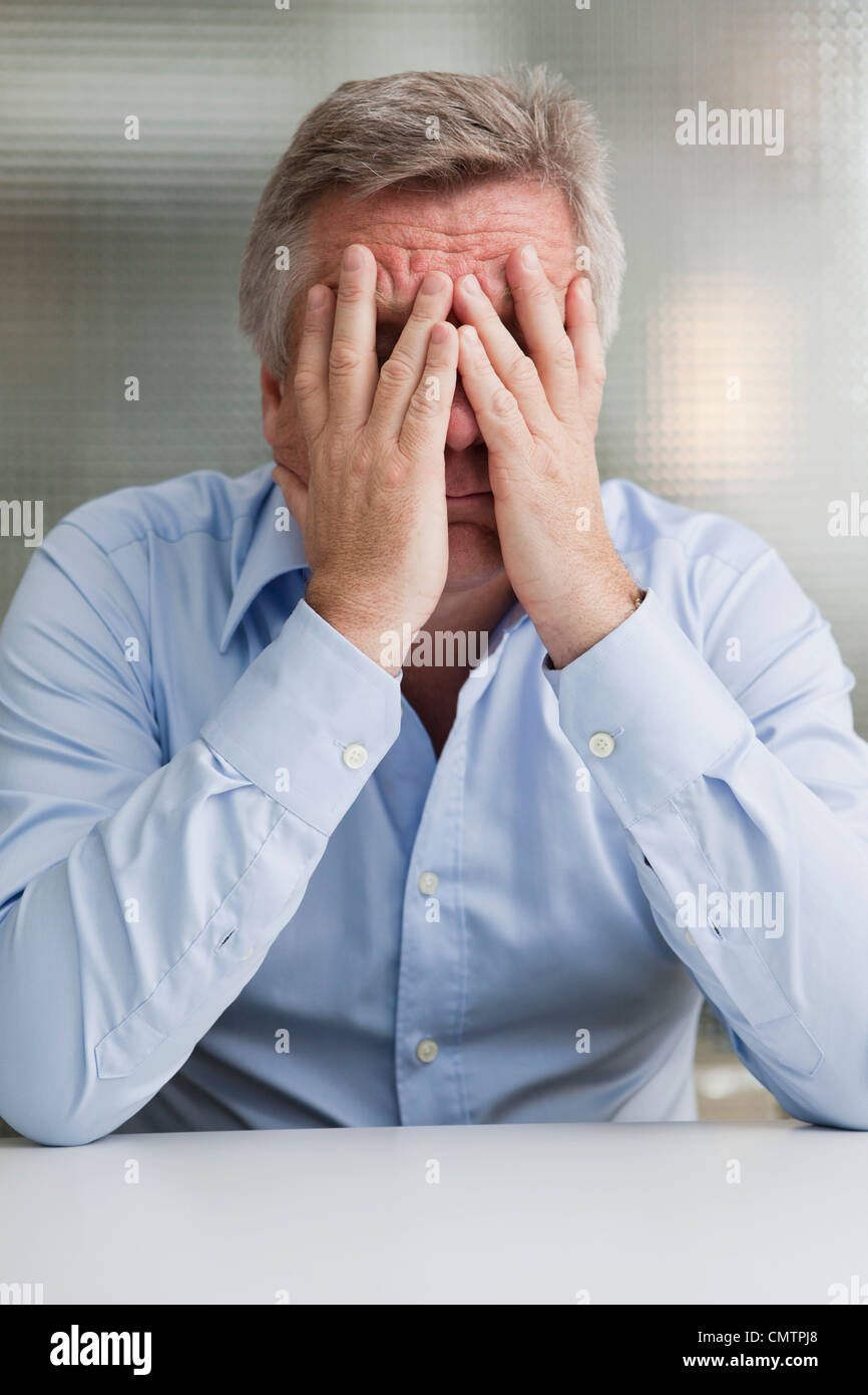 Man holding hands in front of face Stock Photo - Alamy