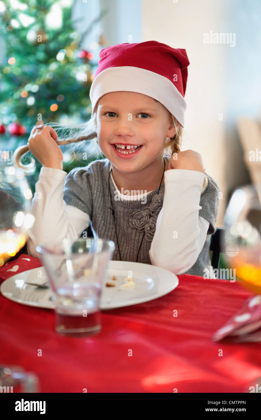 Portrait of smiling girl (6-7) sitting at dinner table looking at ...