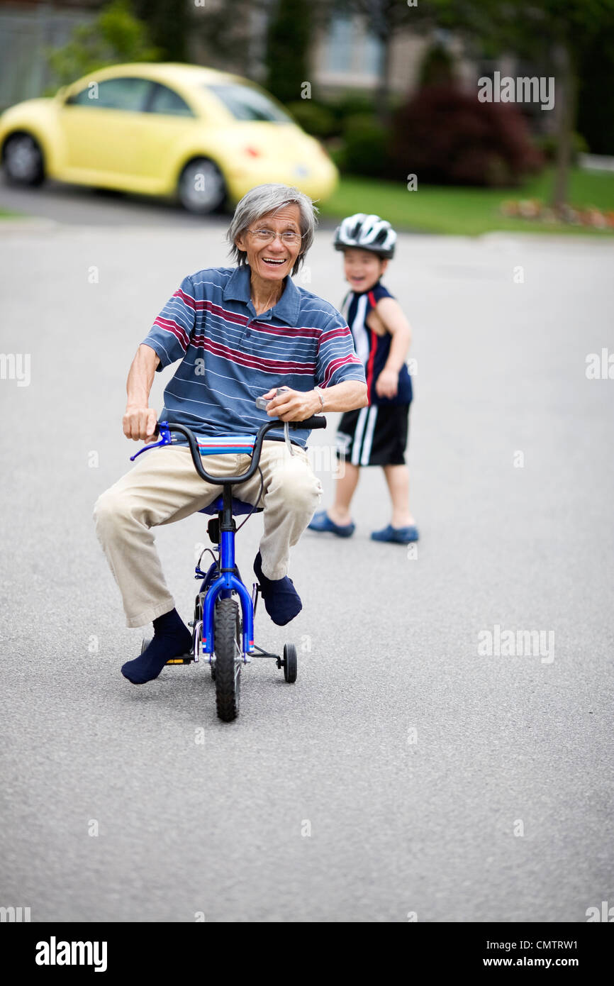 Grandfather riding on his grandsons bicycle, Markham, Ontario Stock ...