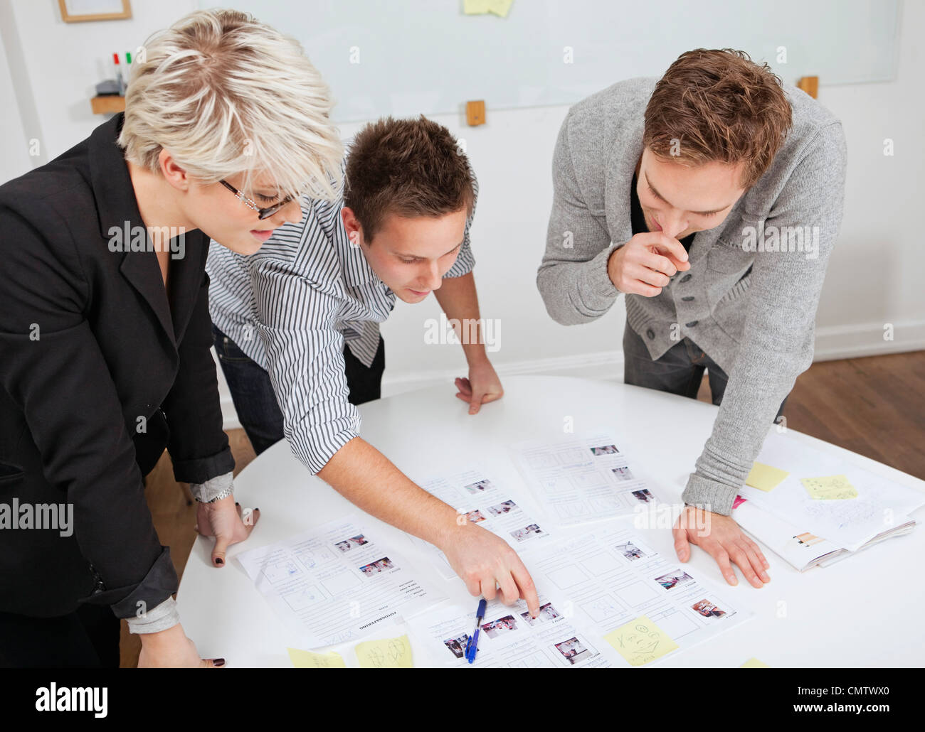 People looking and pointing at papers Stock Photo - Alamy