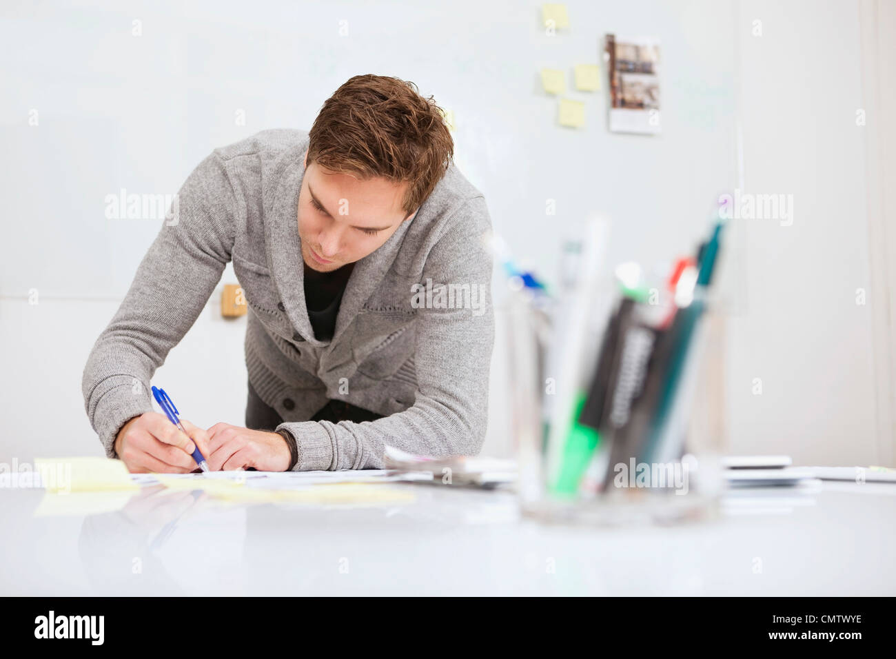 Man leaning over work Stock Photo - Alamy