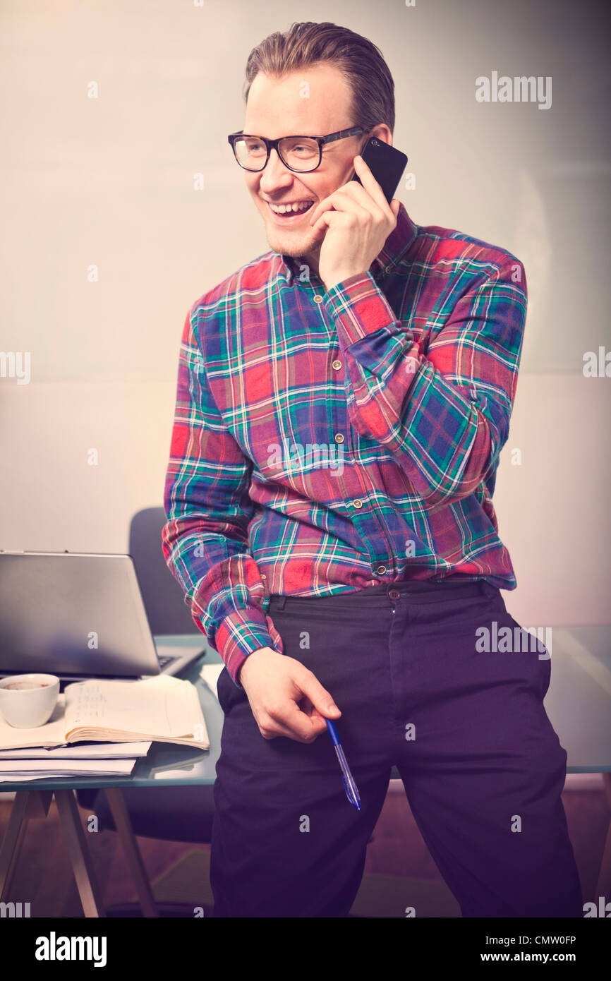 Cheerful businessman on call at workplace Stock Photo - Alamy